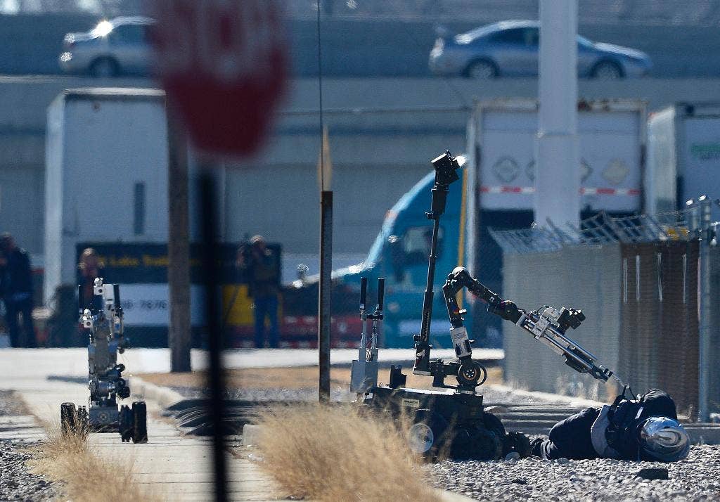 Bank robbery suspect lies on ground as Utah bomb squad robot checks out ...