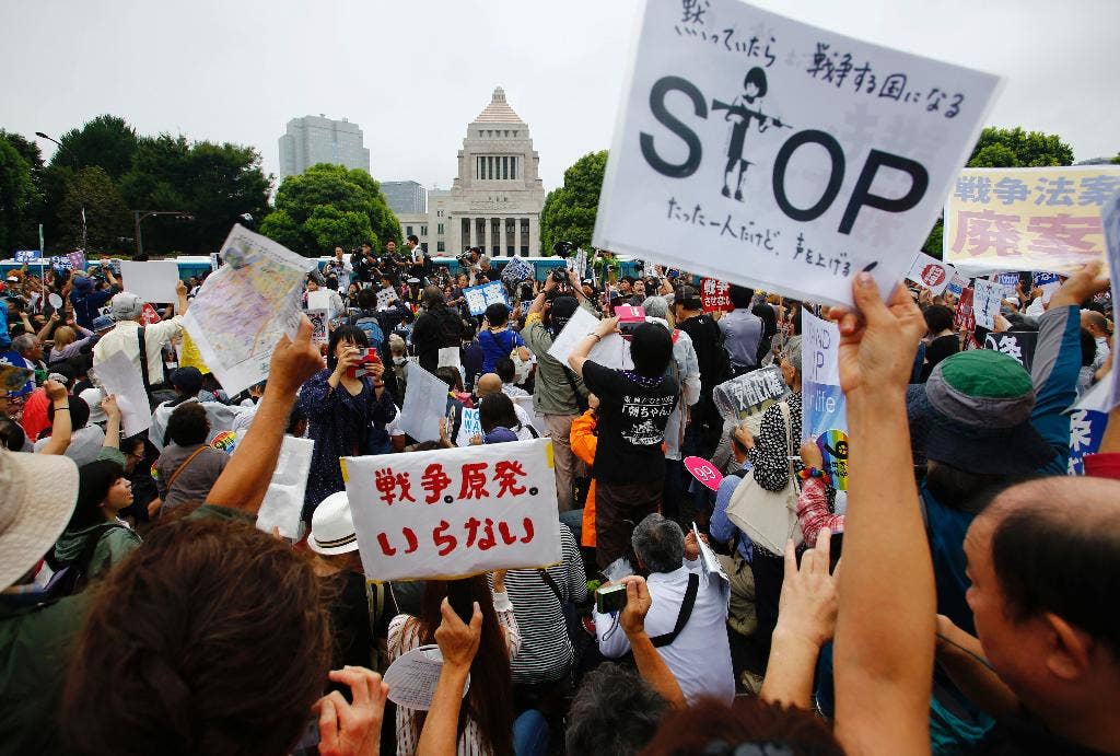 Tens of thousands rally outside Japanese parliament to protest divisive ...