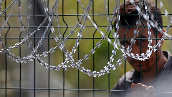 Refugees hopping razor-wire fence into Hungary met with tear gas as EU ...